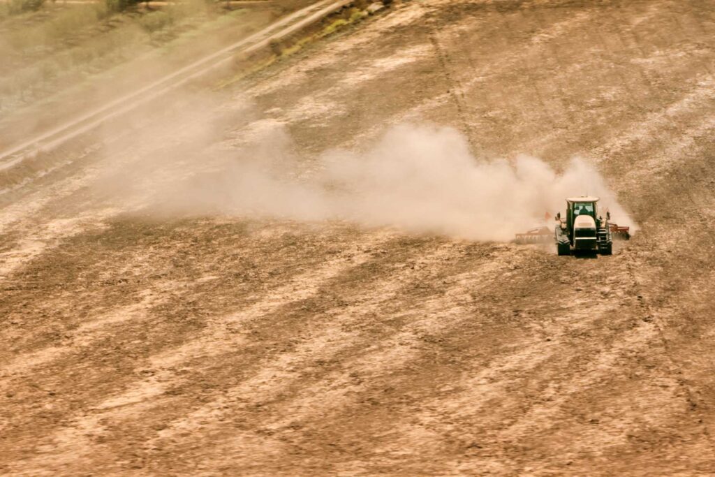 Aerial View of Tractor Kicking Up Dust in Dry Field - Public Policy ...
