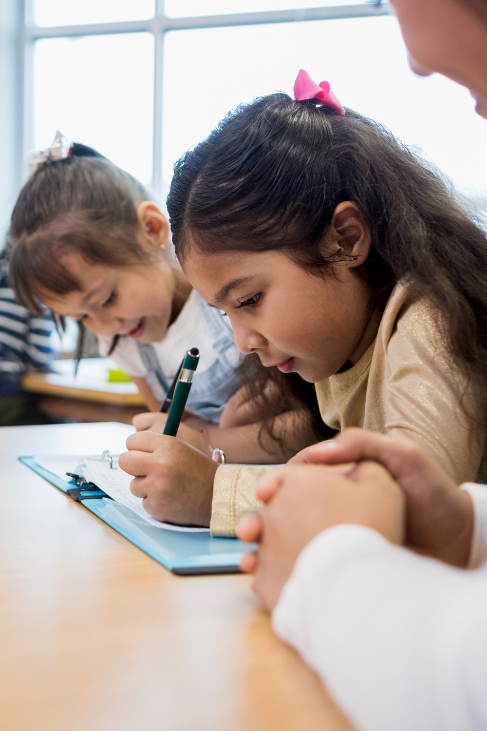 Two Elementary Age Girls Work on Writing Assignment - Public Policy ...