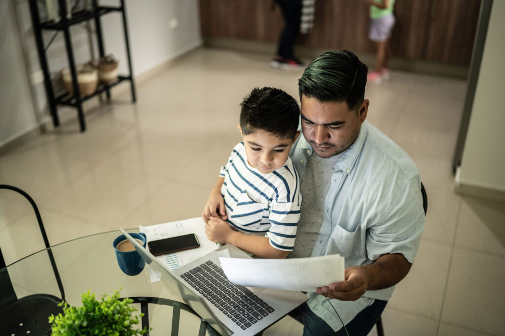 Father Doing Financial Paperwork with Son on Lap - Public Policy ...